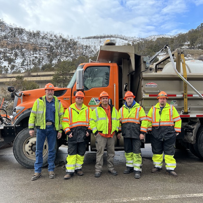 Maintainers in front of a snowplow — Colorado Department of Transportation
