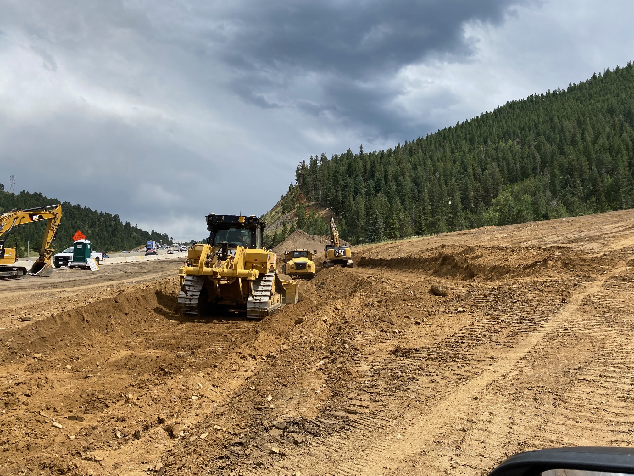 Three pieces of heavy equipment moving dirt for the water quality pond ...